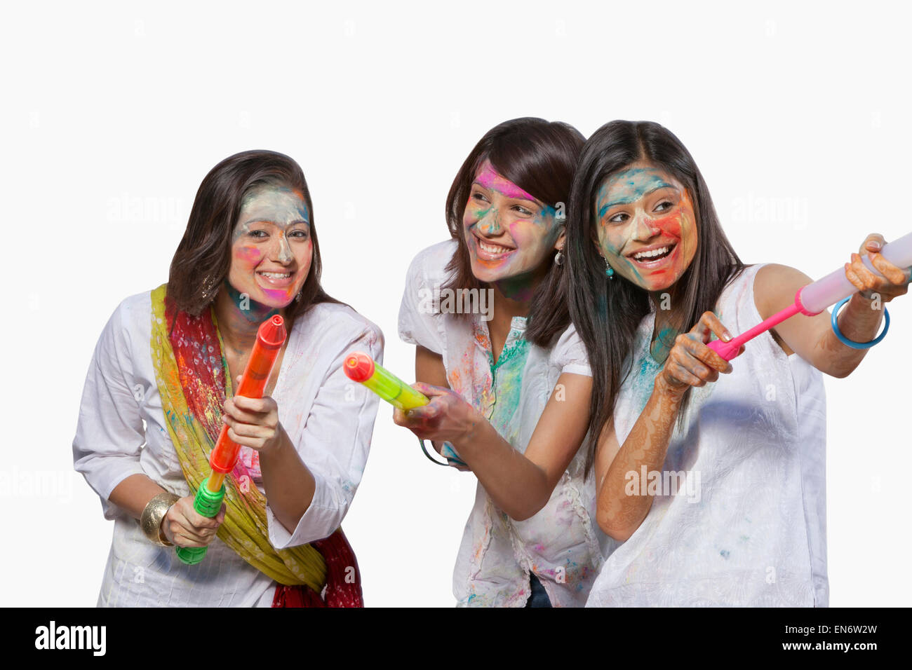 Three women playing holi Stock Photo - Alamy