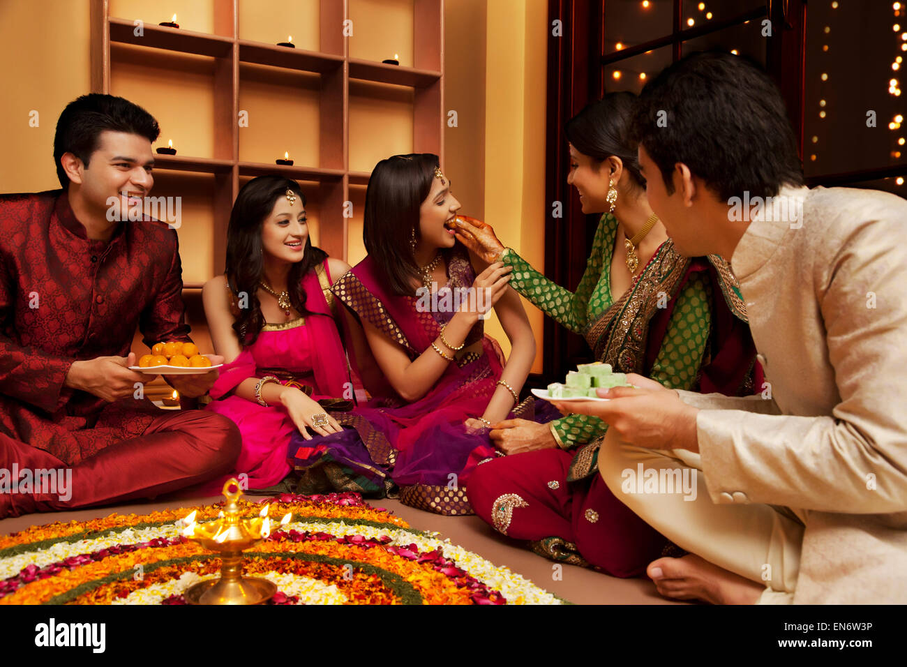 Woman feeding her friend sweets Stock Photo - Alamy