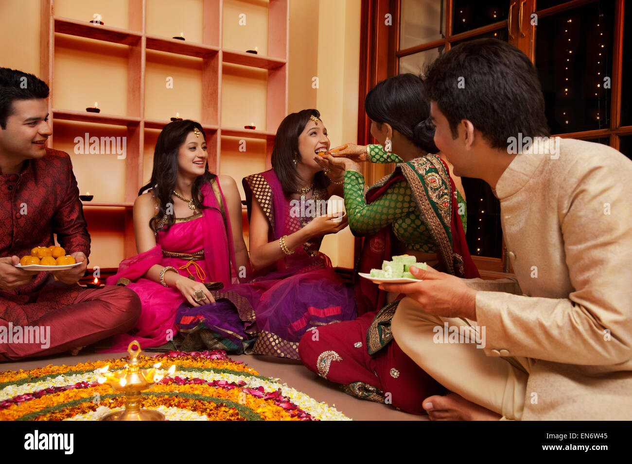 Woman feeding her friend sweets Stock Photo - Alamy