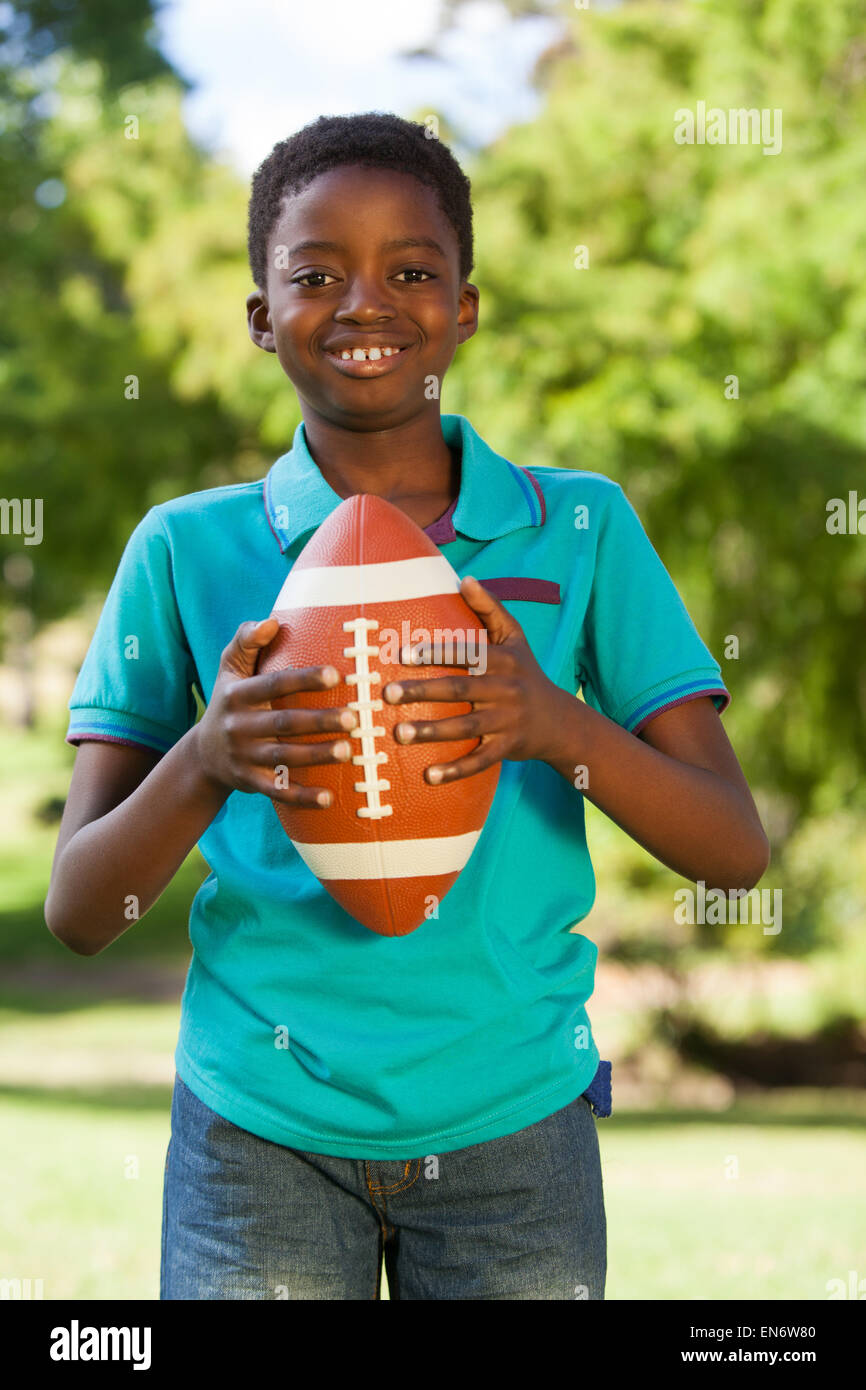 Happy boy in the park with american football Stock Photo - Alamy