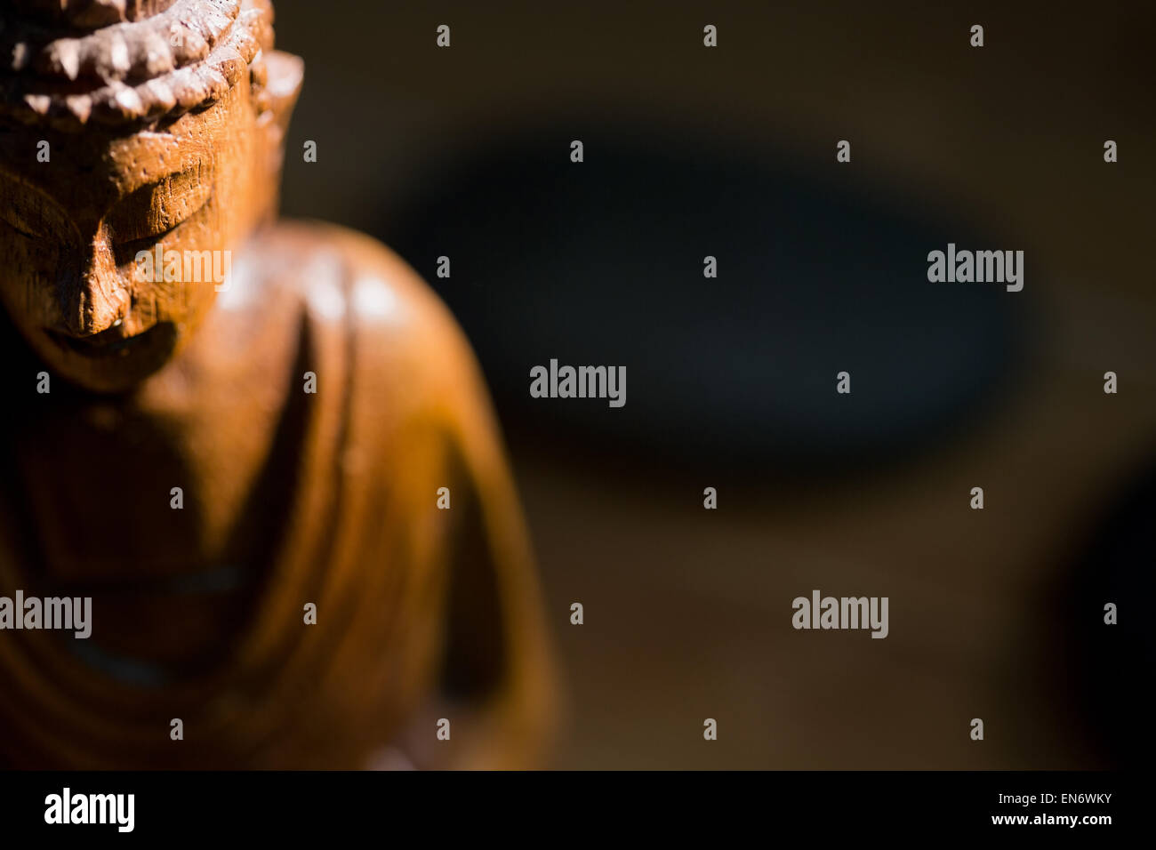 Wooden buddha statue on table Stock Photo - Alamy