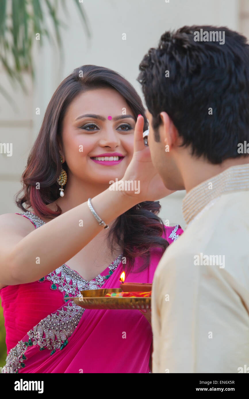 Woman putting tika on mans forehead Stock Photo - Alamy