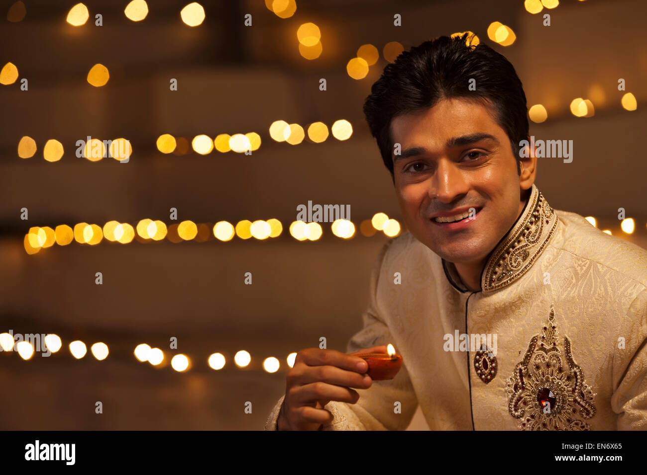 Portrait of man holding a diya Stock Photo - Alamy