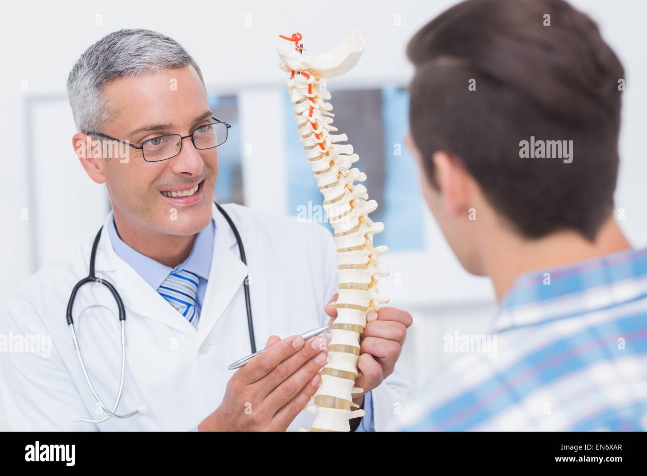 Doctor showing anatomical spine to his patient Stock Photo - Alamy