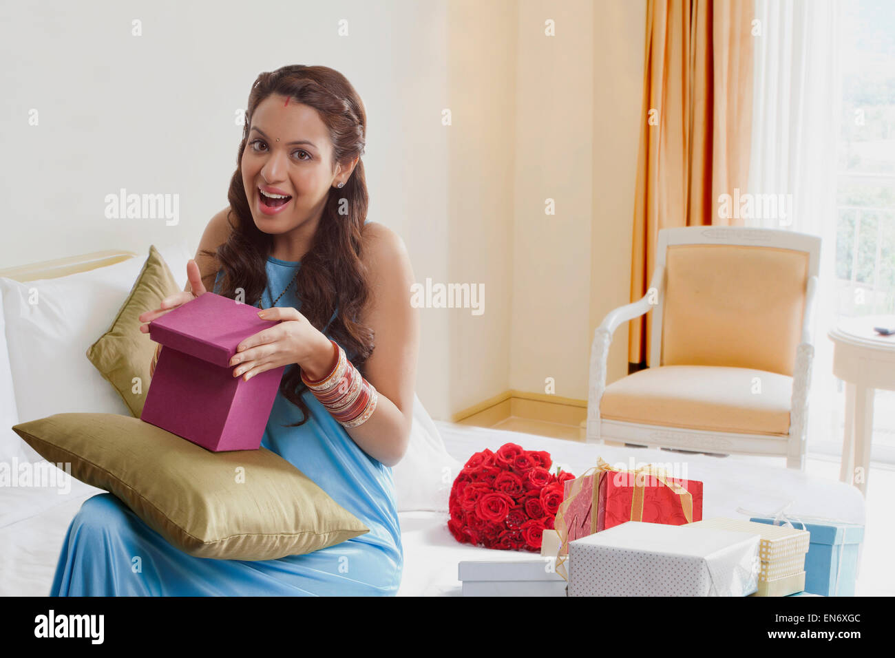 Portrait of woman opening gift box Stock Photo - Alamy