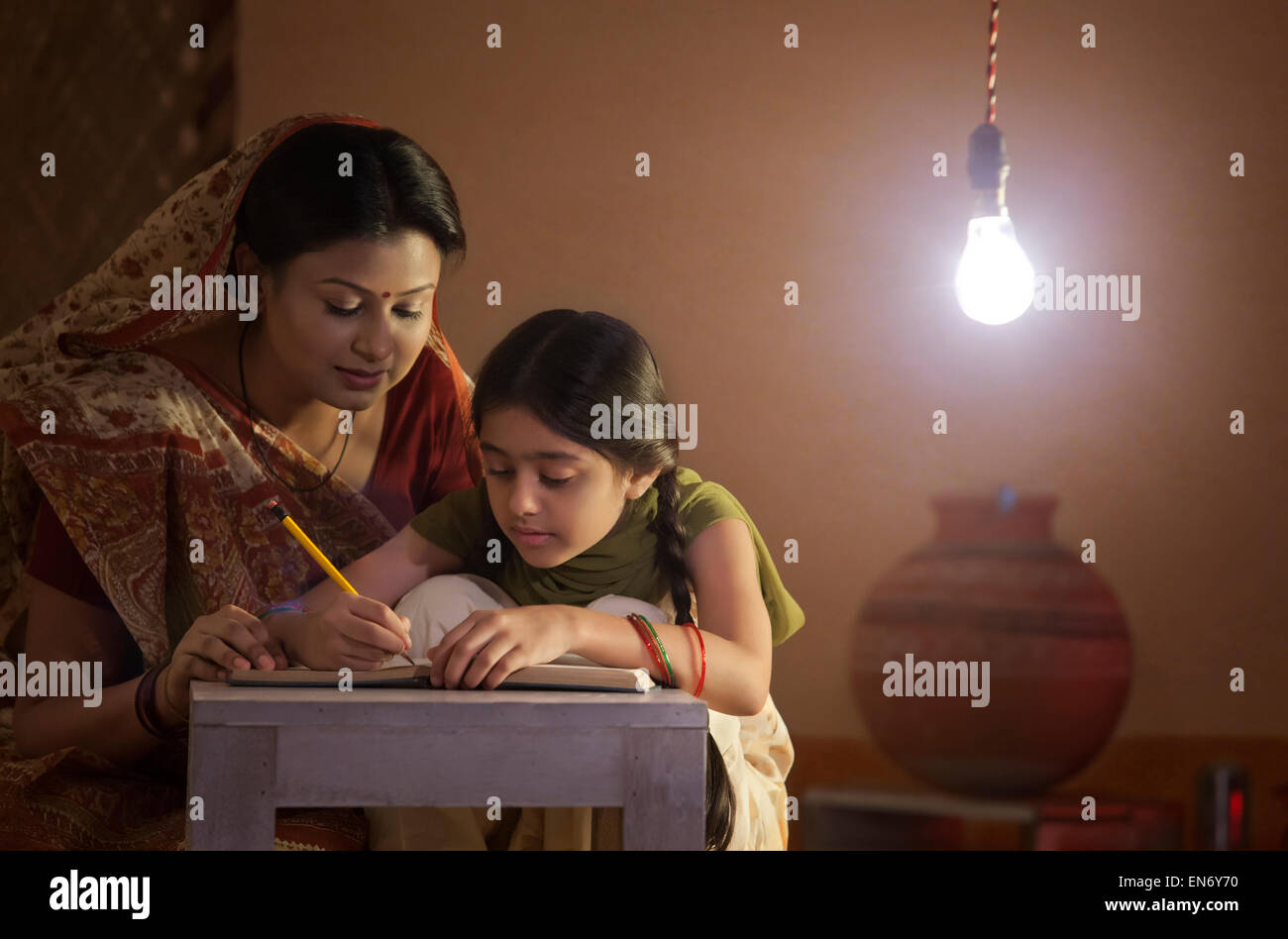 Mother helping daughter study Stock Photo - Alamy