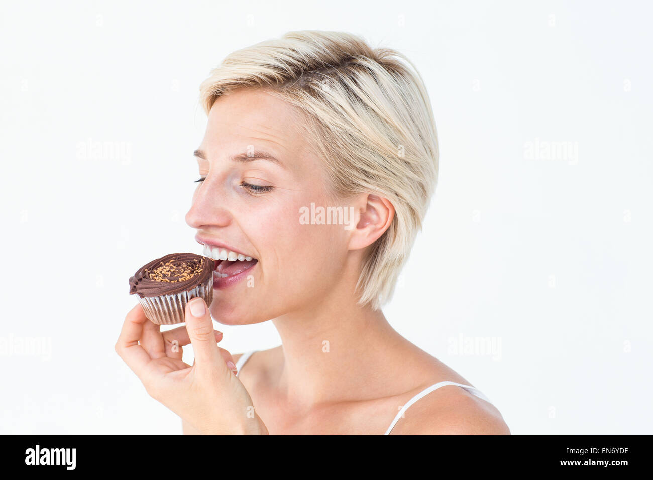 Attractive woman eating muffin Stock Photo - Alamy