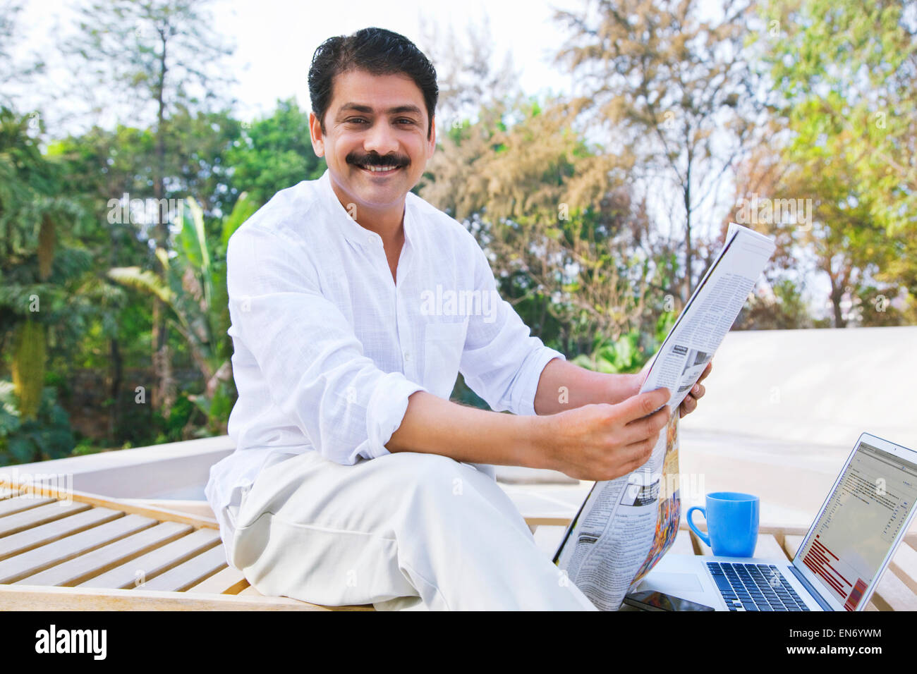 Portrait of a man with newspaper smiling Stock Photo - Alamy