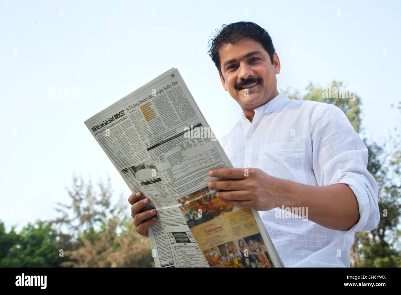 Portrait of a man with newspaper smiling Stock Photo - Alamy