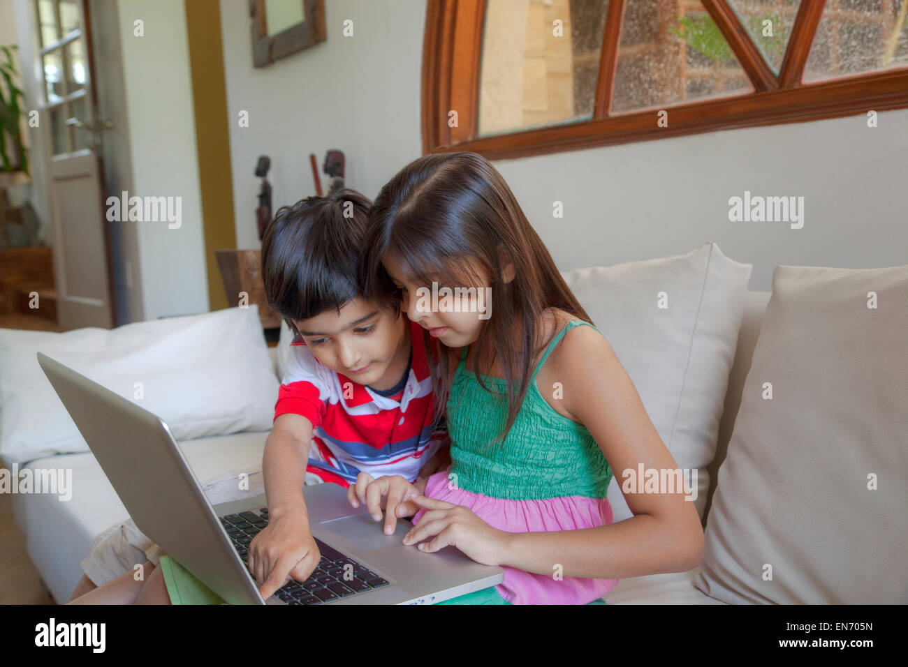 Brother and sister working on a laptop Stock Photo - Alamy