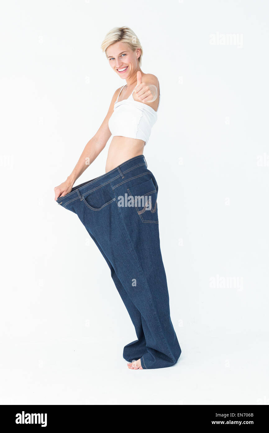Blonde wearing too large pants with the thumb up Stock Photo - Alamy