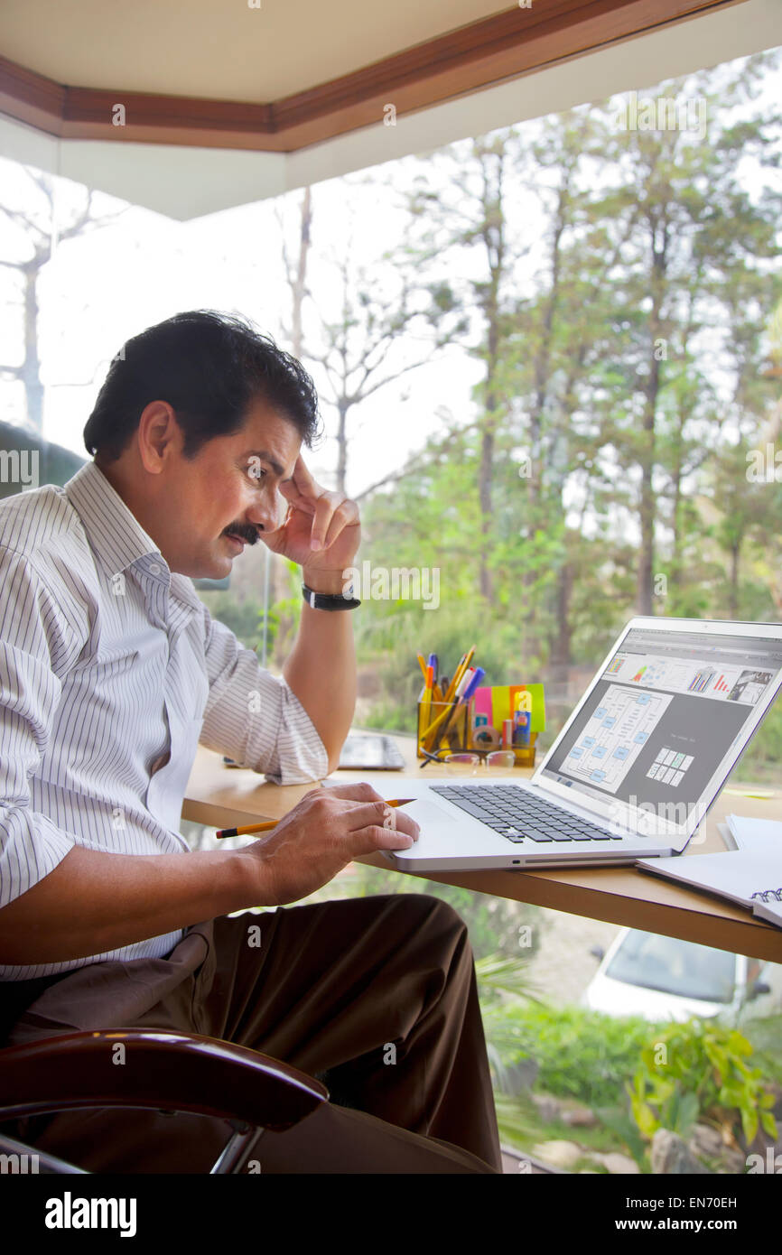 Man thinking while working on laptop Stock Photo - Alamy
