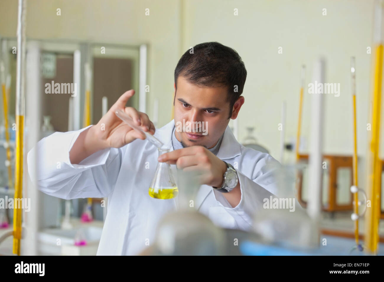 College student holding a beaker with liquid Stock Photo - Alamy