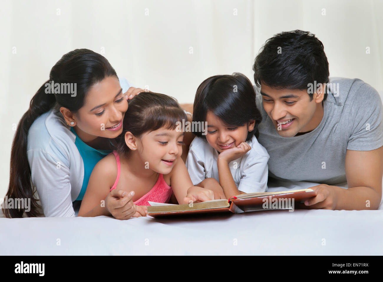 Family reading a book Stock Photo - Alamy