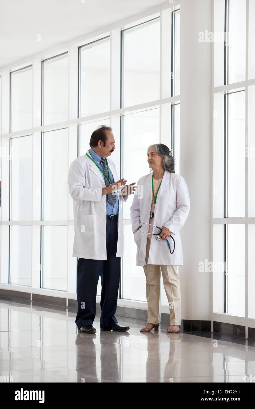 Two doctors talking in hospital corridor Stock Photo - Alamy