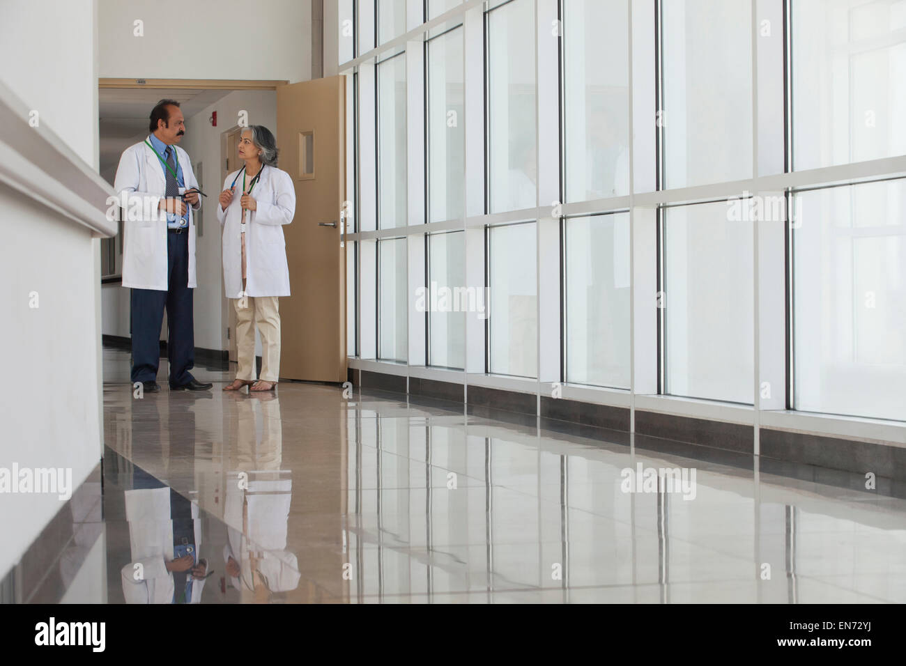 Two doctors talking in hospital corridor Stock Photo - Alamy