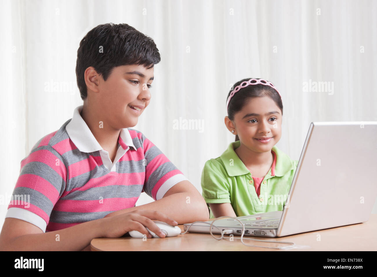 Brother and sister using laptop Stock Photo - Alamy