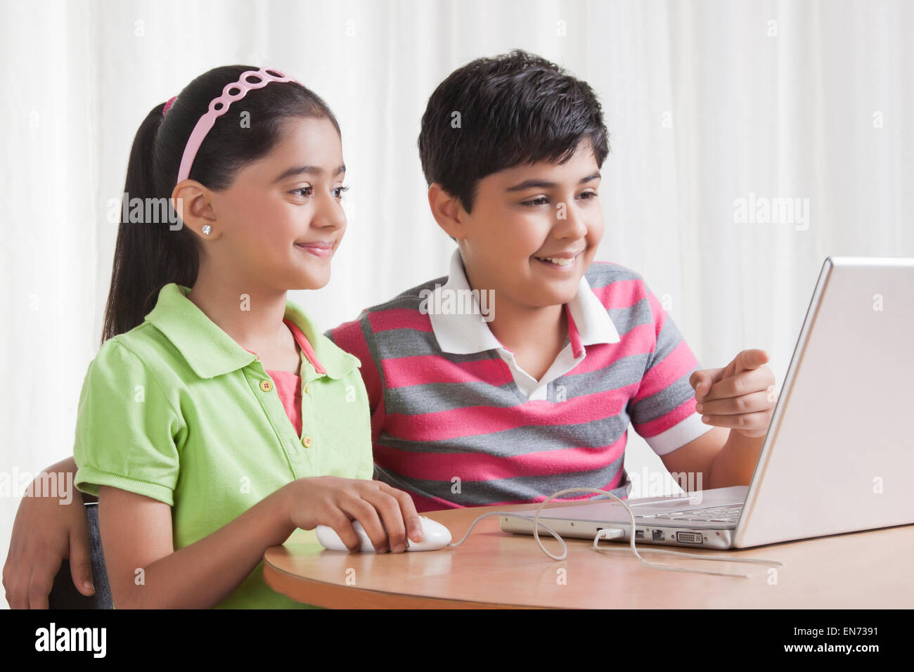 Brother and sister using laptop Stock Photo - Alamy