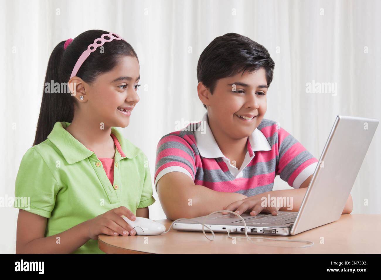 Brother and sister using laptop Stock Photo - Alamy