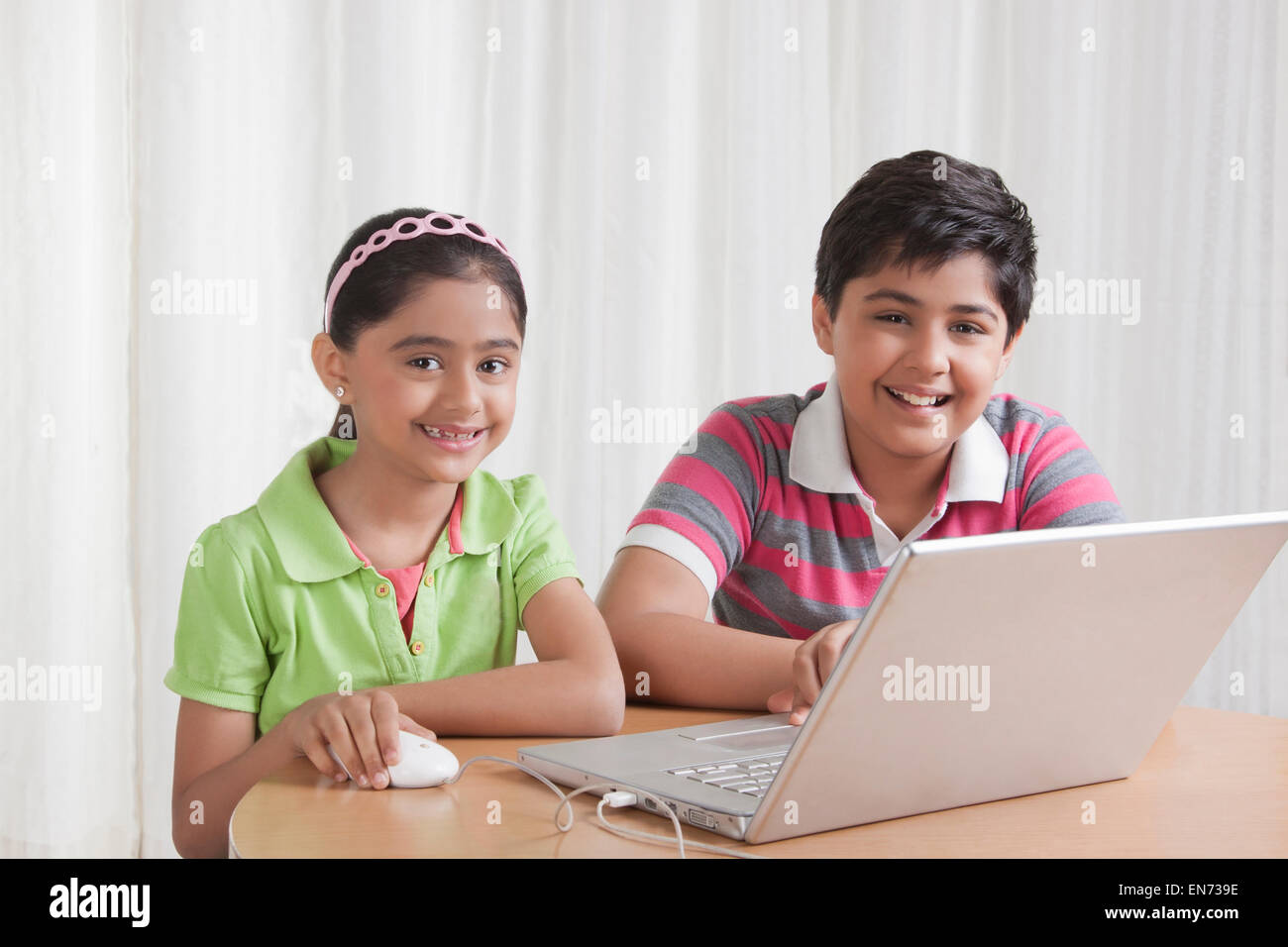 Portrait of brother and sister using laptop Stock Photo - Alamy