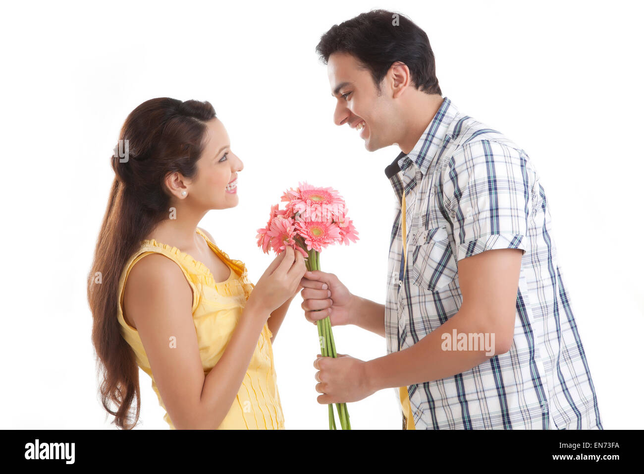 Indian man giving flowers to woman Cut Out Stock Images & Pictures - Alamy