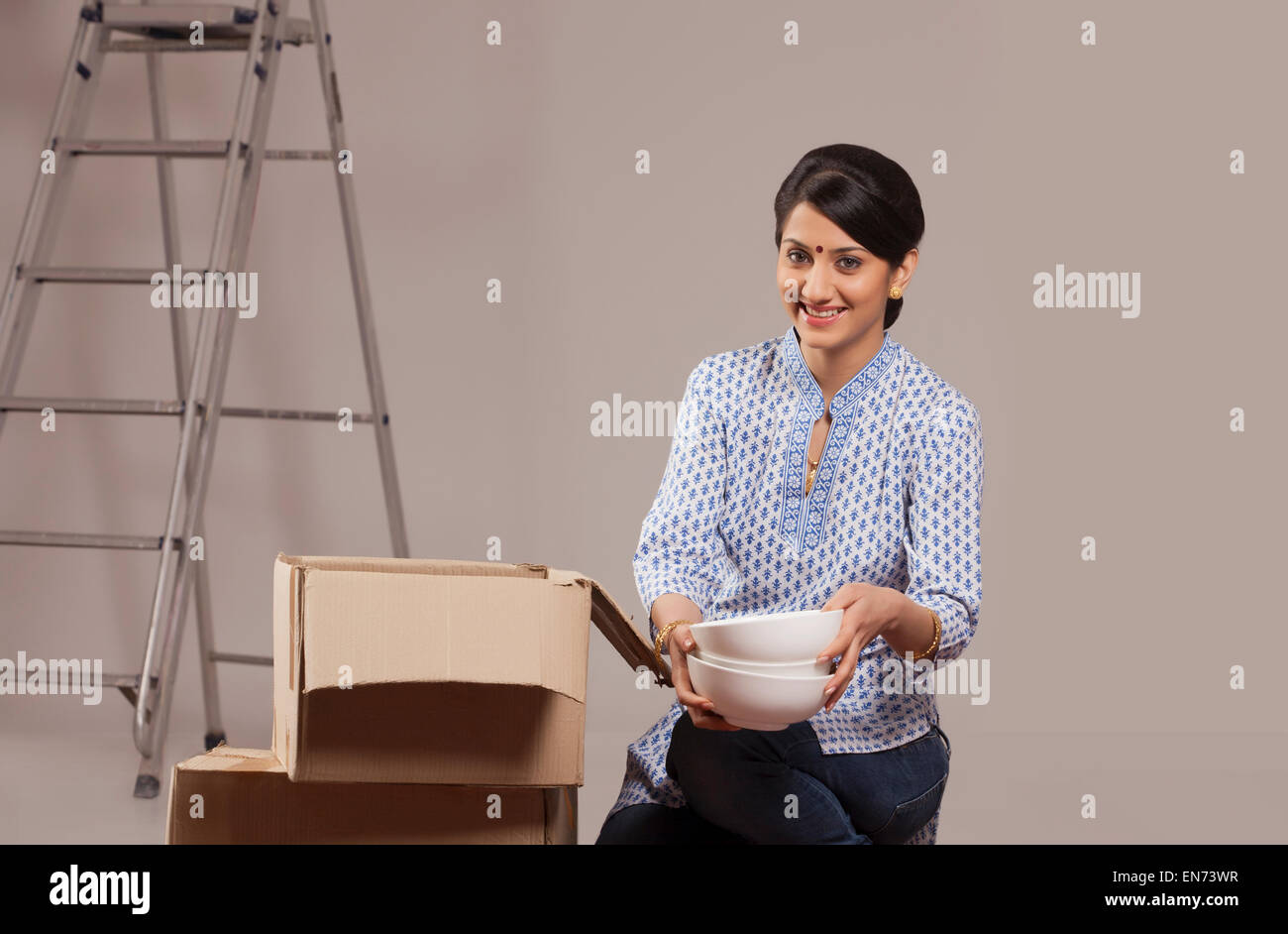 Young woman packing crockery Stock Photo - Alamy