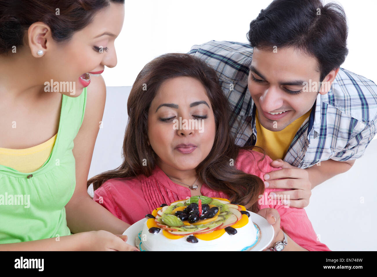 Woman blowing out candle on cake Stock Photo - Alamy