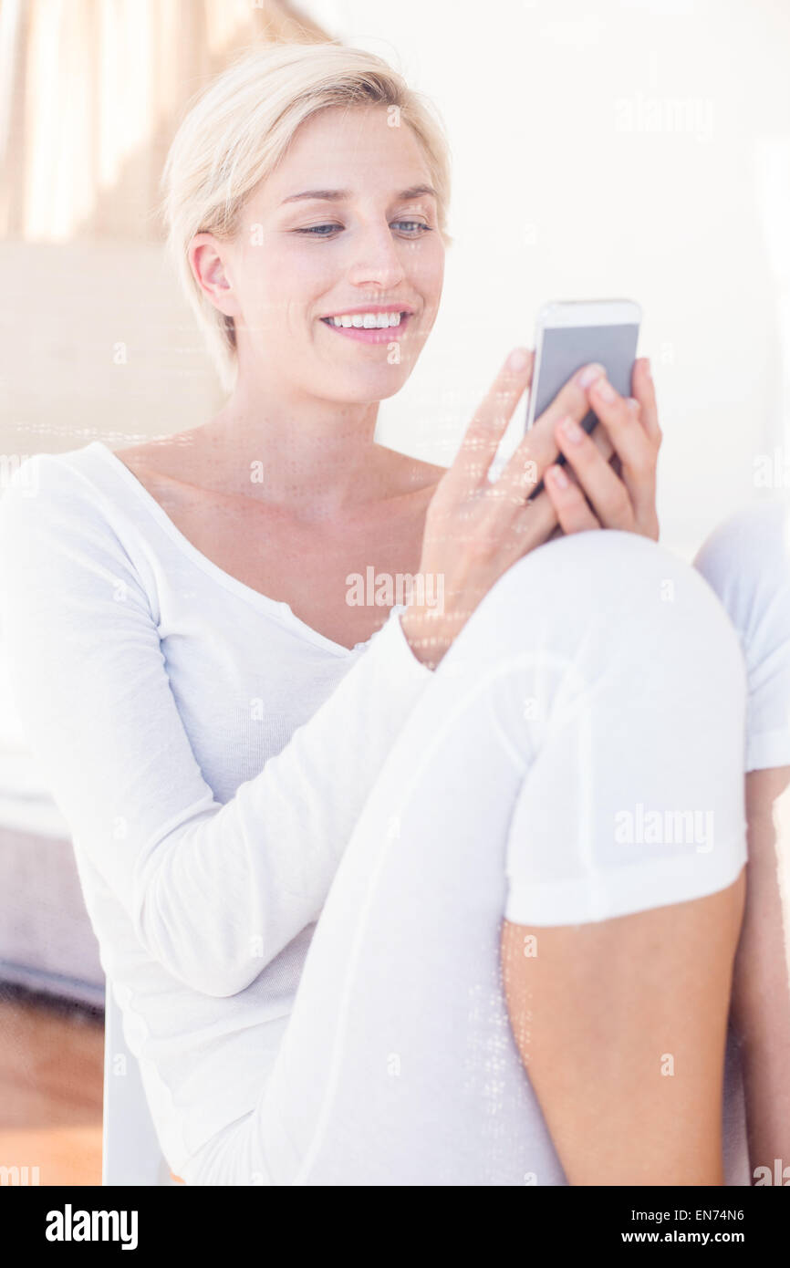 Smiling blonde woman texting with her mobile phone Stock Photo - Alamy