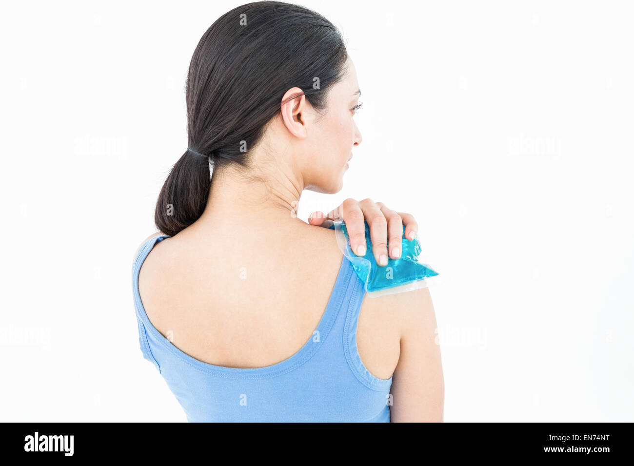 Beautiful brunette putting gel pack on shoulder Stock Photo - Alamy