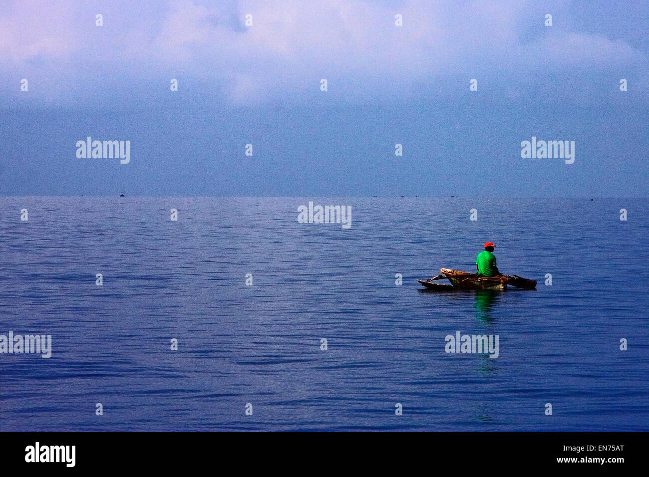 man alone in the sea and a boat Stock Photo - Alamy