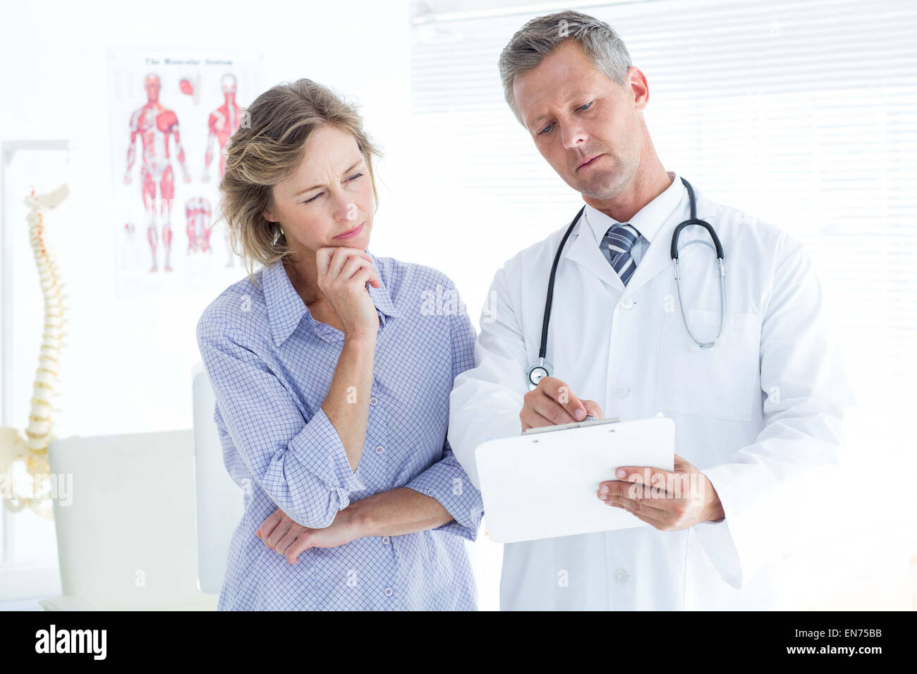 Doctor showing his notes to his patient Stock Photo - Alamy