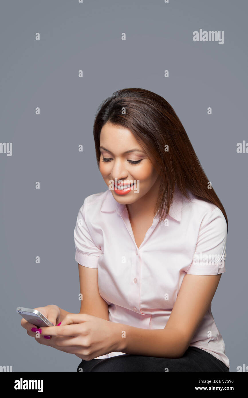 Female executive texting on mobile phone Stock Photo - Alamy