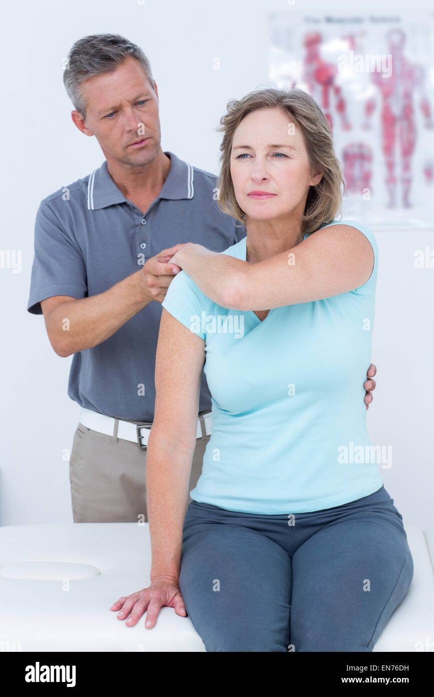 Woman stretching her arm with her doctor Stock Photo - Alamy