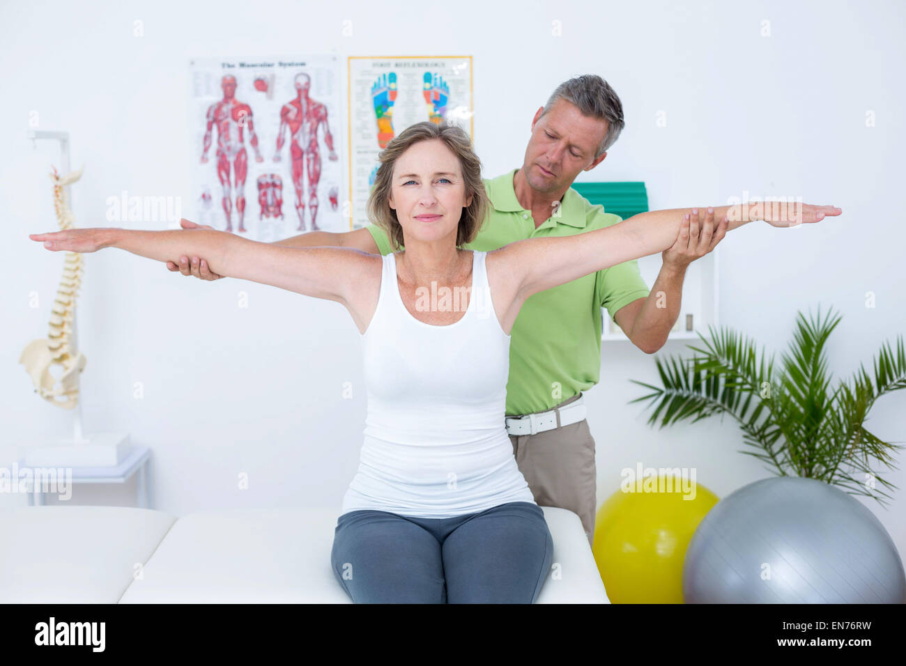 Doctor stretching his patients arms Stock Photo - Alamy