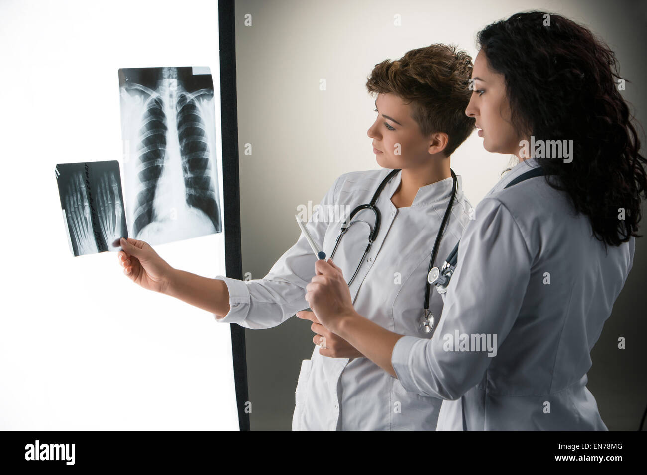 Two attractive young doctors looking at x-ray results Stock Photo - Alamy