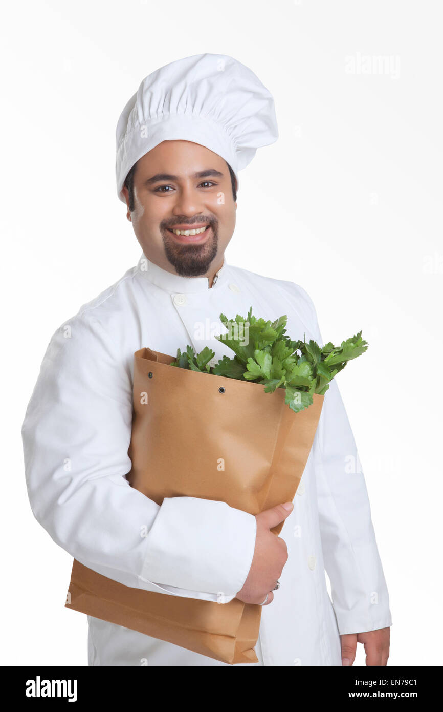 Portrait of chef with bag of vegetables Stock Photo - Alamy