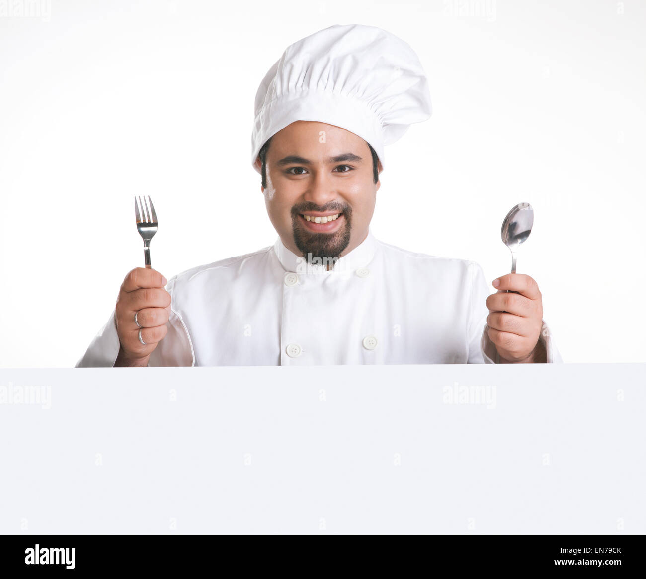 Portrait of chef with fork and spoon smiling Stock Photo - Alamy