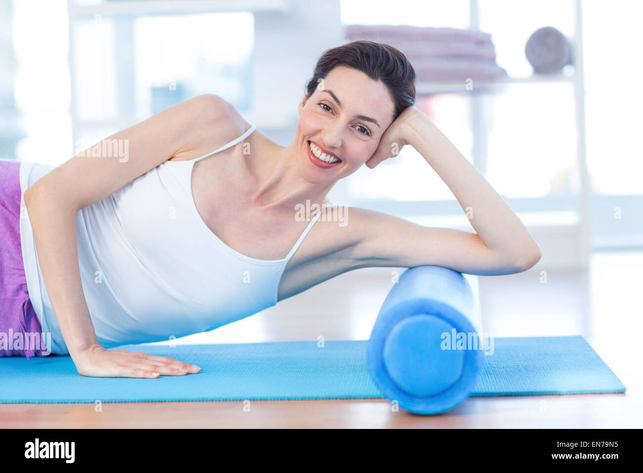 Smiling woman lying on exercise mat Stock Photo - Alamy