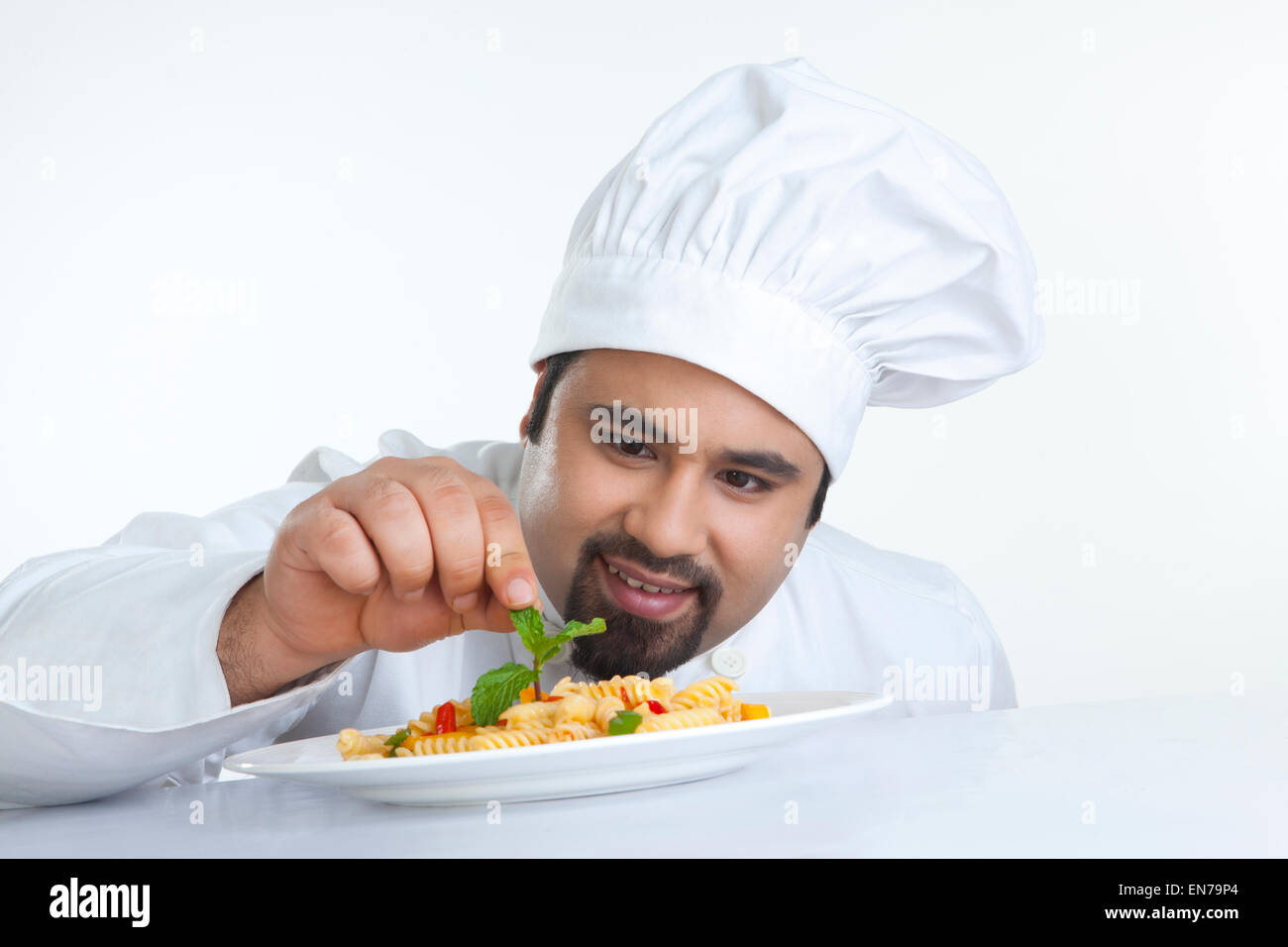 Chef decorating pasta with leaf Stock Photo - Alamy