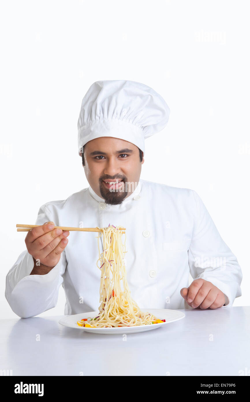 Portrait of chef lifting pasta with chopsticks Stock Photo - Alamy