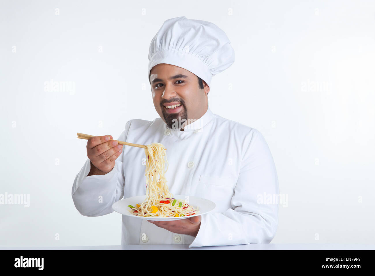 Portrait of chef lifting pasta with chopsticks Stock Photo - Alamy