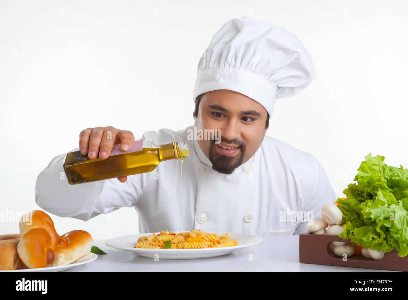 Chef pouring olive oil on pasta Stock Photo - Alamy
