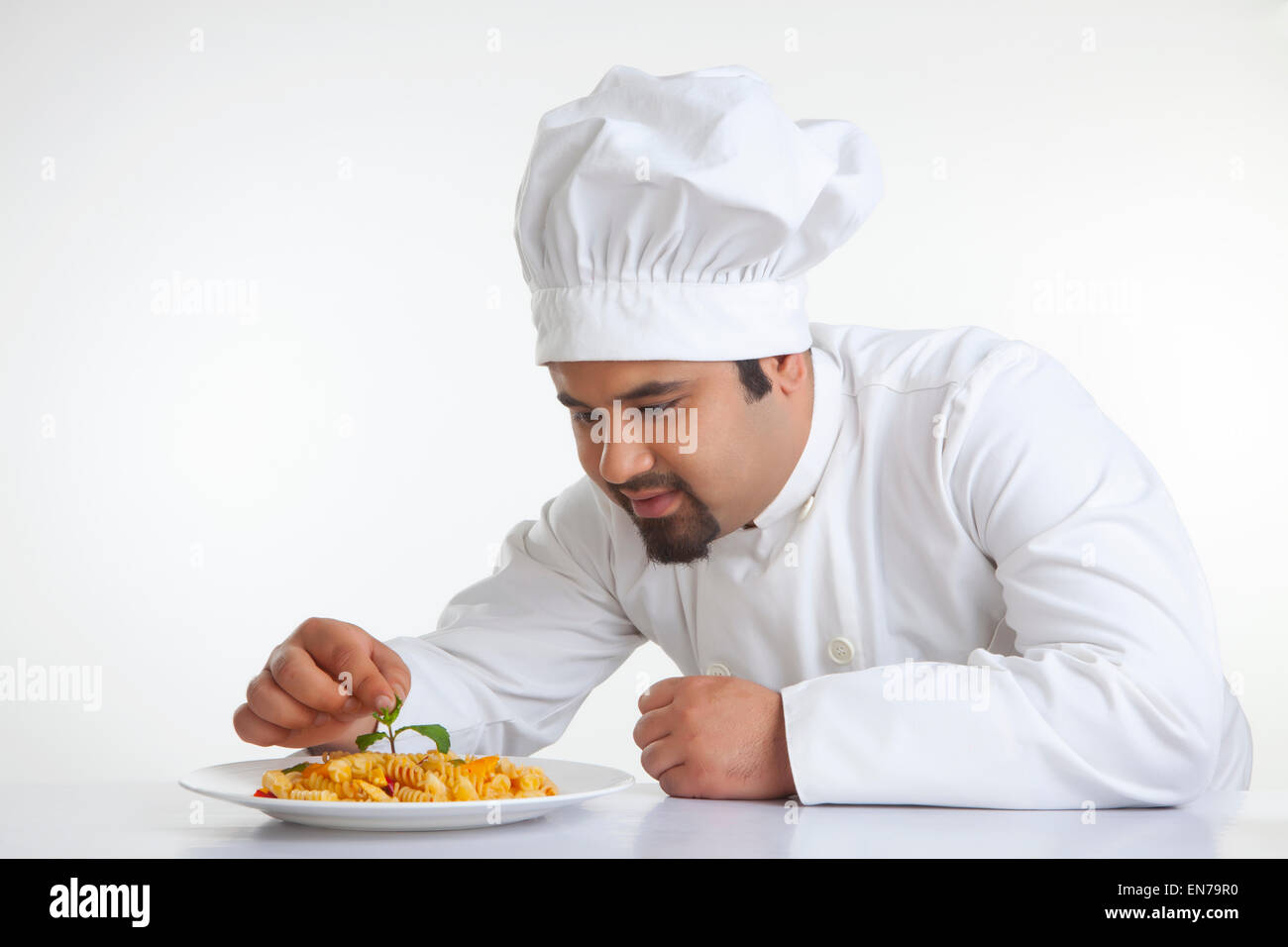 Chef decorating pasta with leaf Stock Photo - Alamy