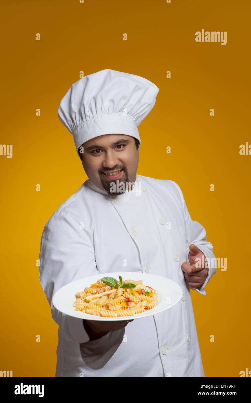 Portrait of chef with plate of pasta Stock Photo - Alamy
