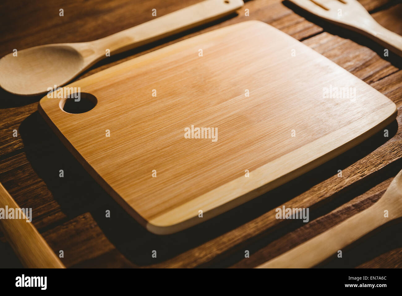 Chopping board with wooden utensils Stock Photo - Alamy
