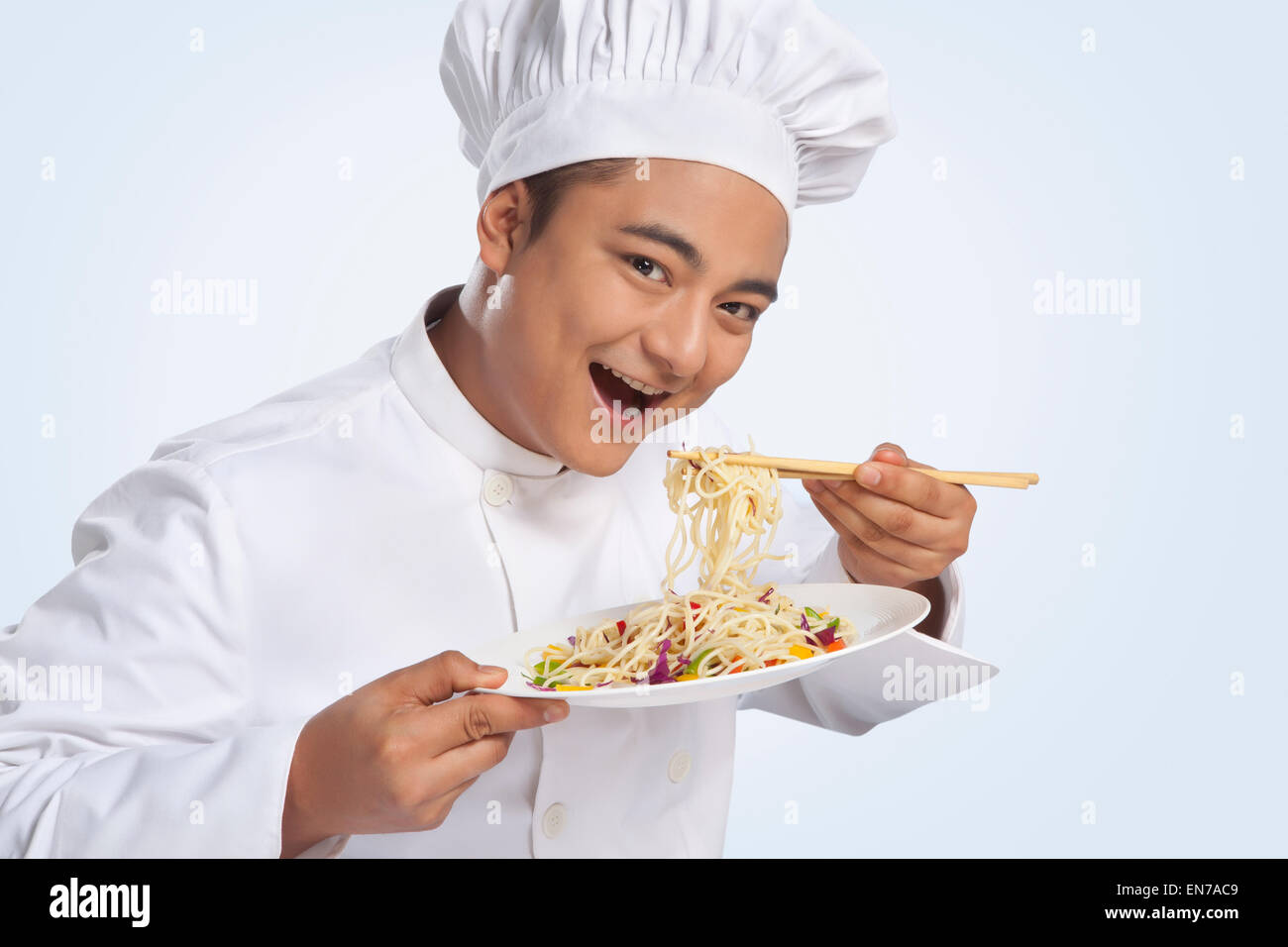 Portrait of chef eating pasta with chopsticks Stock Photo - Alamy