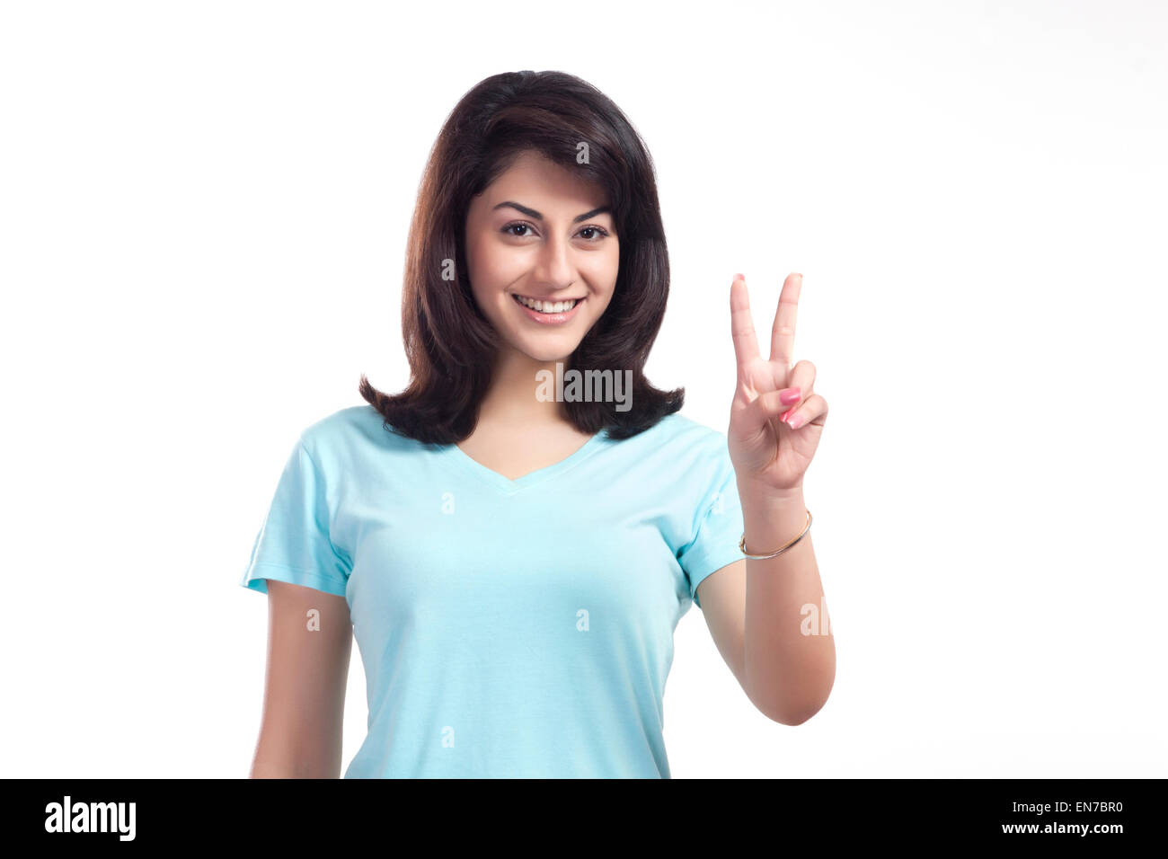 Portrait of a woman giving peace sign Stock Photo - Alamy