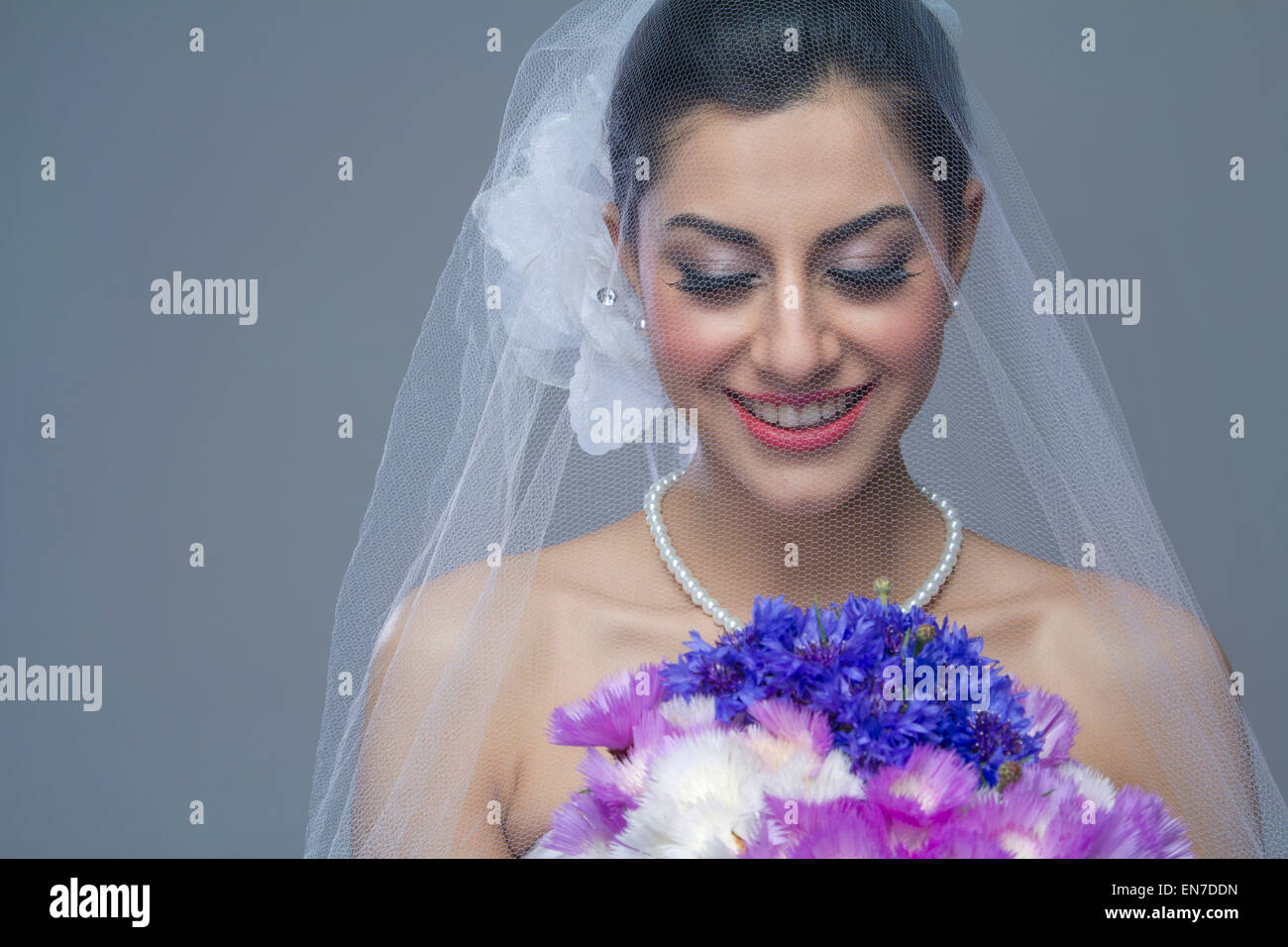 Bride with flowers smiling Stock Photo - Alamy