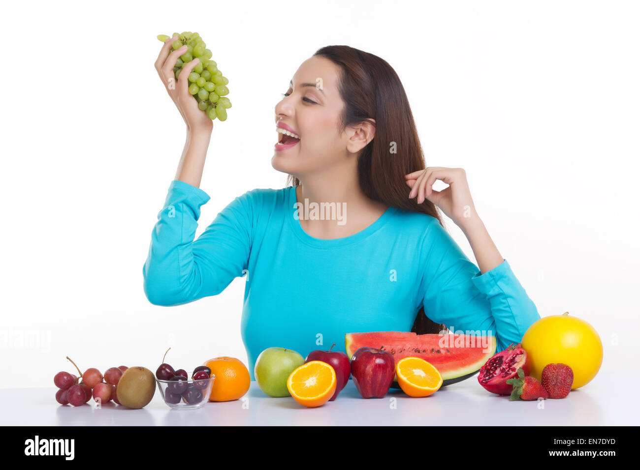 Woman about to eat grapes Stock Photo - Alamy