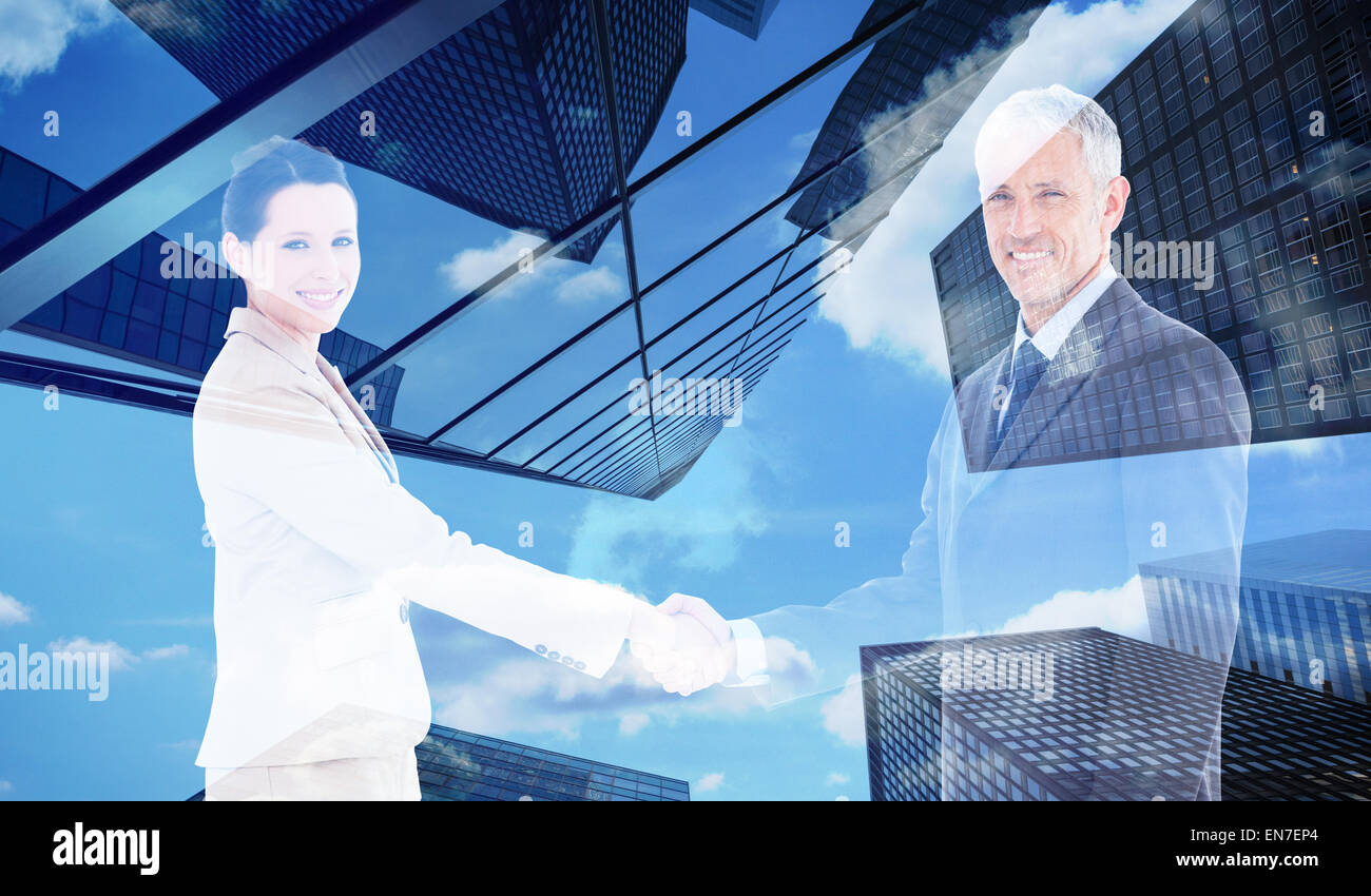 Composite image of smiling business people shaking hands while looking ...